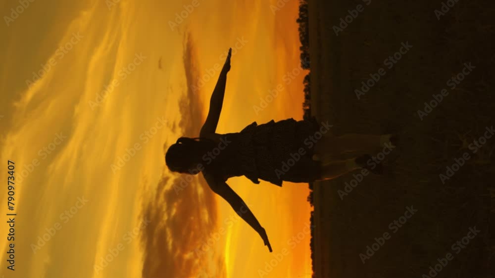 Child girl runs with his arms raised like wings of an airplane ...