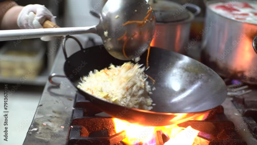 Chef wearing black uniform and white sterile gloves, skillfully cooking ...