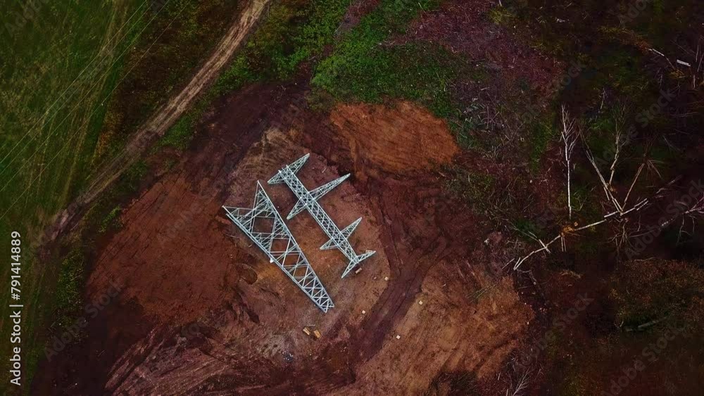 Parts of a high-voltage pylon to be installed lie on the ground. Drone ...