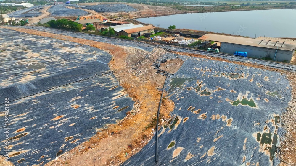 An aerial perspective reveals a landfill hidden under layers of black ...