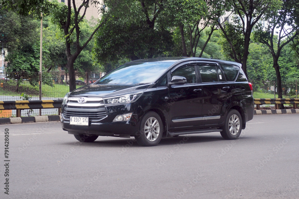 Black color MPV Toyota Kijang Innova, in a road, at business and ...