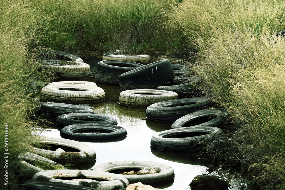 The reservoir is littered with car tires. Pollution of the environment ...