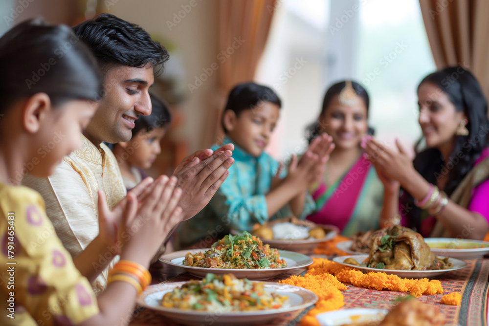 Multi-generational Indian family in traditional dress enjoying a ...