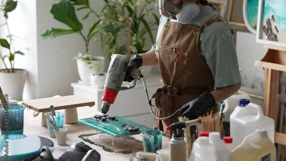 Artist girl works with flowable epoxy resin creates paintings in studio ...