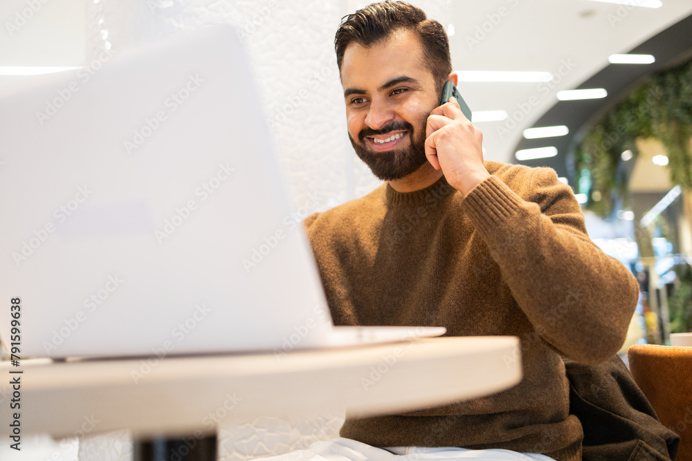 Engaged and personable, a man conducts a phone conversation with a warm ...