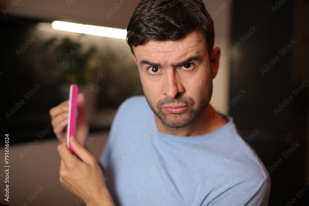 Judgmental looking man doing doing his nails Stock Photo | Adobe Stock