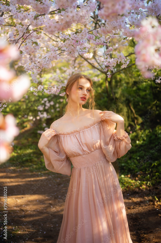 Beautiful girl in pink vintage dress standing near colorful flowers ...