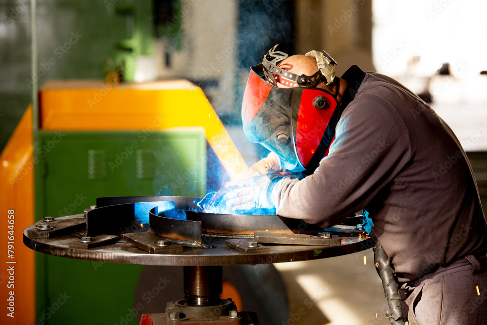 Welding master welding while paying attention to occupational safety in ...