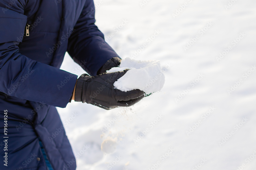 pile of snow in hands after heavy snowfall. man in gloves and winter ...