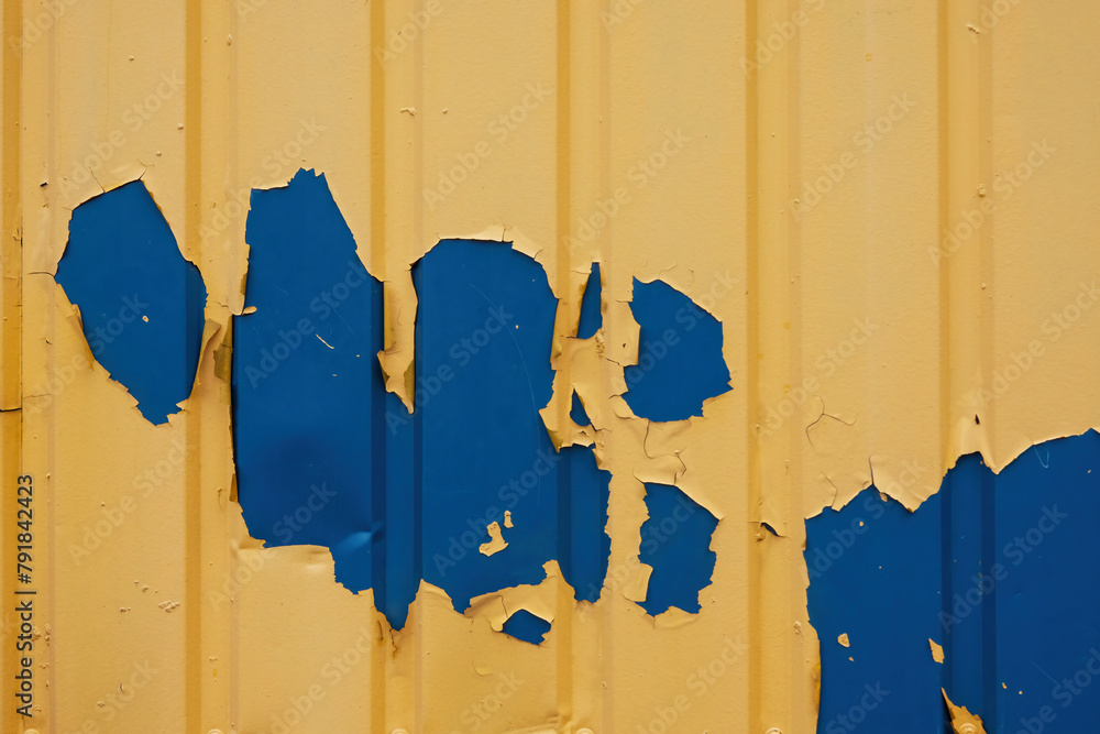 Fragment of a metal corrugated sheet of a wall. The top layer of yellow ...