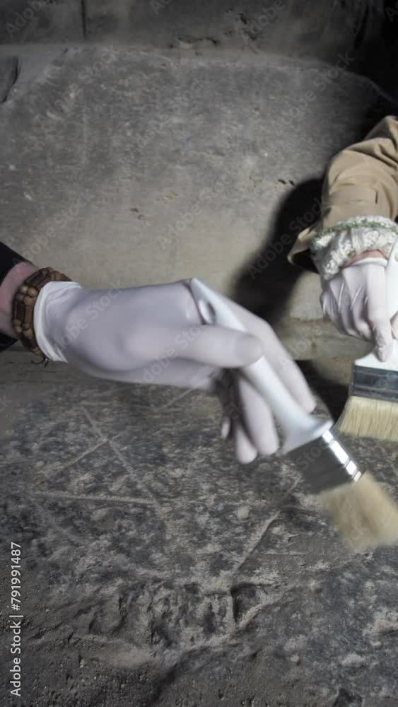 Vidéo Stock Vertical: The gloved hands of two archaeologists use work ...