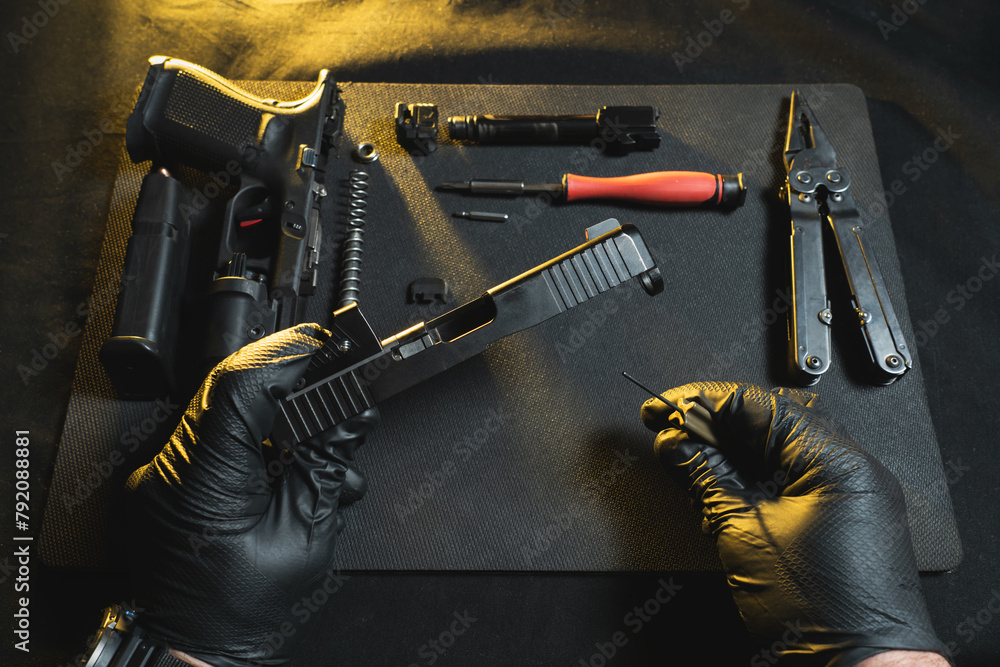 Cleaning and repairing weapons. Hands of a gunsmith and a disassembled ...