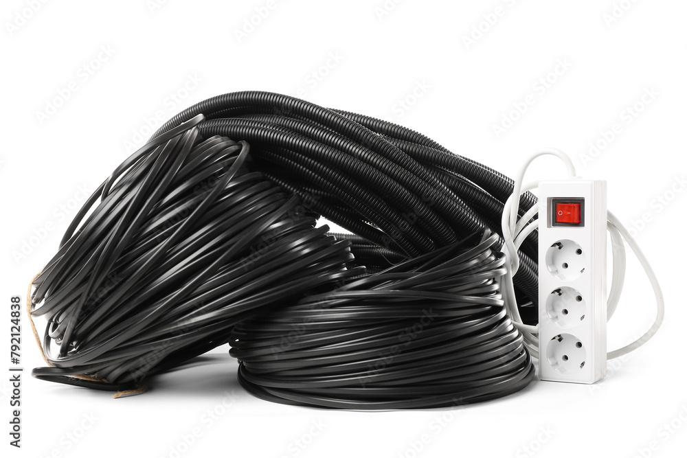 Rolled cables, flexible conduit tube and extension cord on white ...