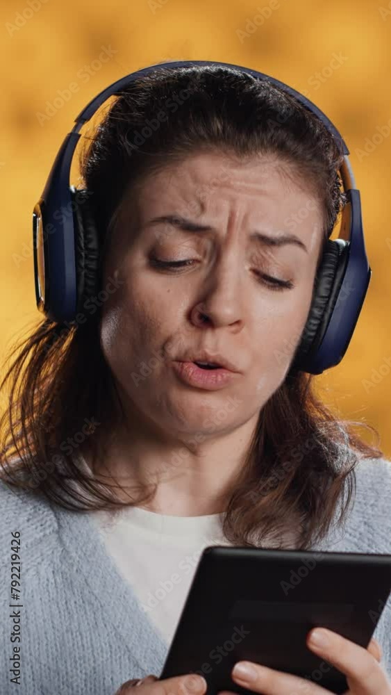 Vertical video Voice actor frowns while reading ebook, portraying ...