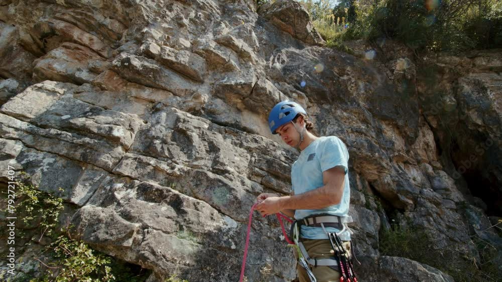 Climber man preparing for climbing up the rocky wall rift by checking ...