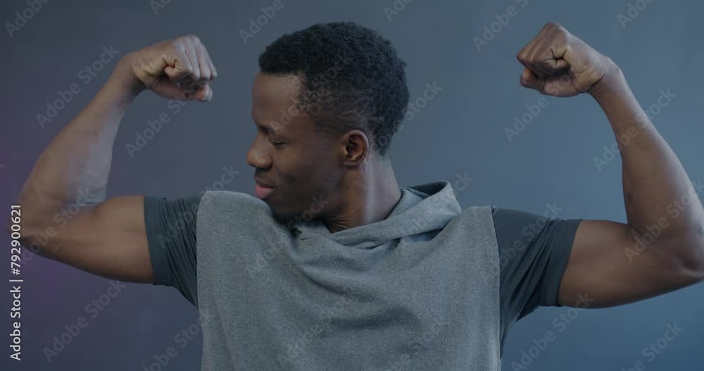 Portrait of muscular African American bodybuilder showing biceps and ...
