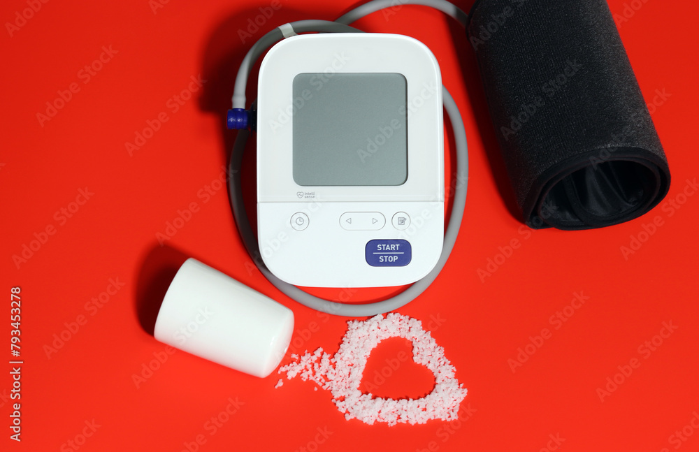 Electronic blood pressure gauge and electrocardiogram-shaped salt on a ...