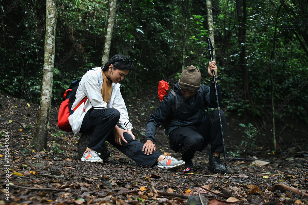 Couple of hikers in the mountain forest having issue with pain in the ...