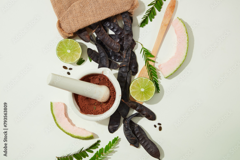 Above view photo with black locust pods, lemon, fern, wooden spoon ...