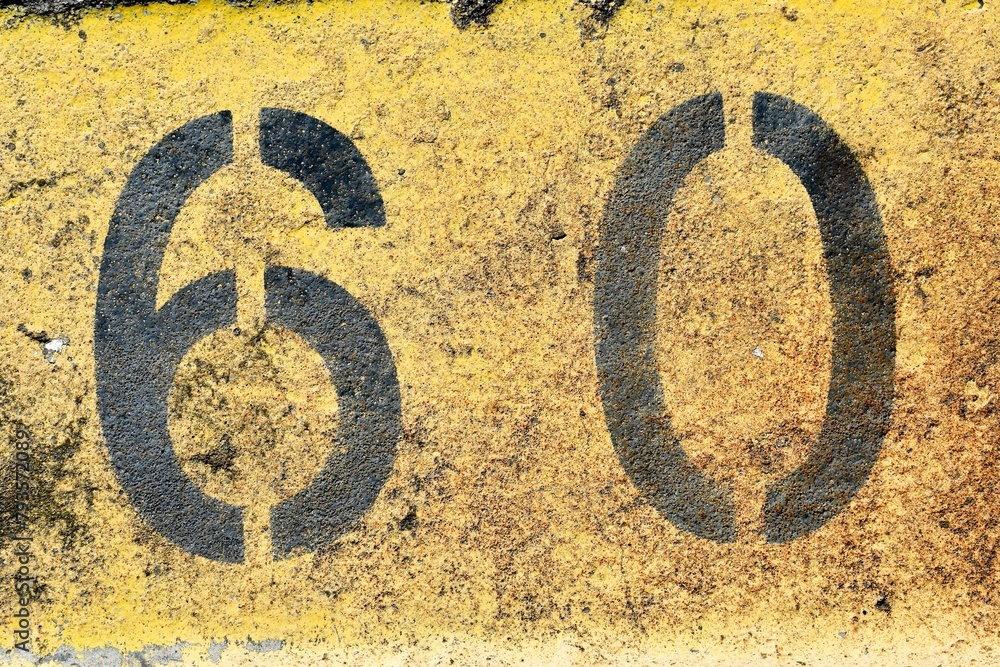 The number 60, sixty, six zero; painted in black and yellow; an ...