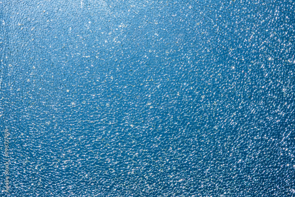 The surface of the glass panel is covered with small holes and cracks ...