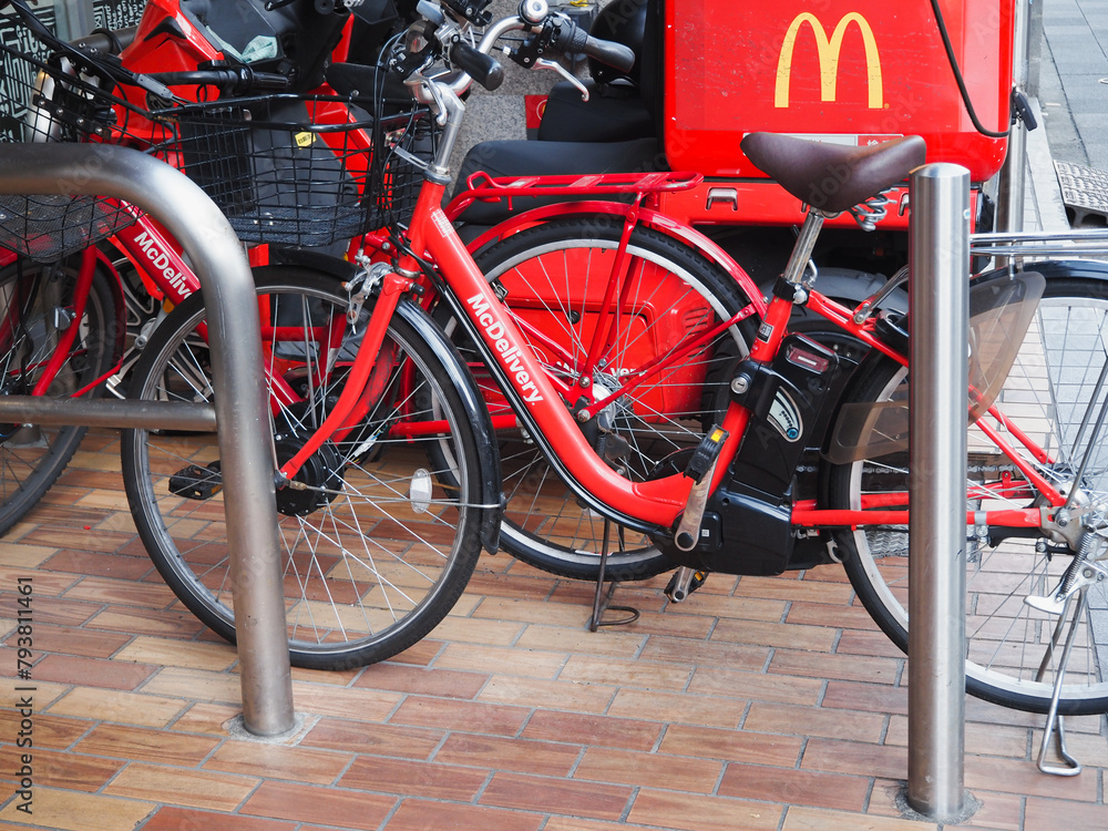 TOKYO, JAPAN - April 7, 2024: McDonalds McDelivery electric bicycles parked by delivery scooters ...
