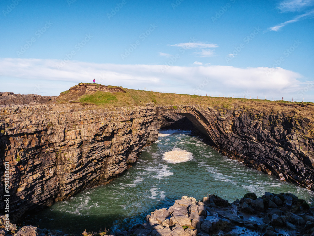 Tourist enjoy stunning Bridges of Ross in county Clare, Ireland. Rock ...
