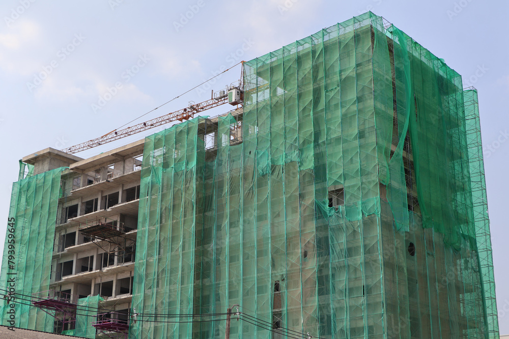 High-rise buildings under construction have coverings to prevent debris ...