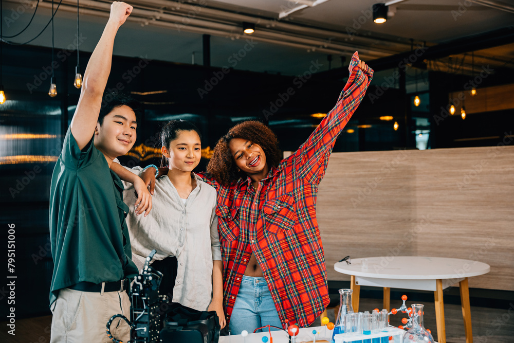 In classroom environment jubilant group of students raises hands ...