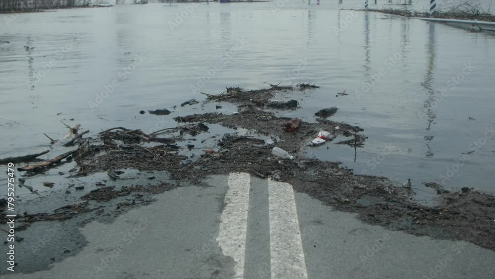 Asphalt road is submerged under muddy flood water and impassable for ...