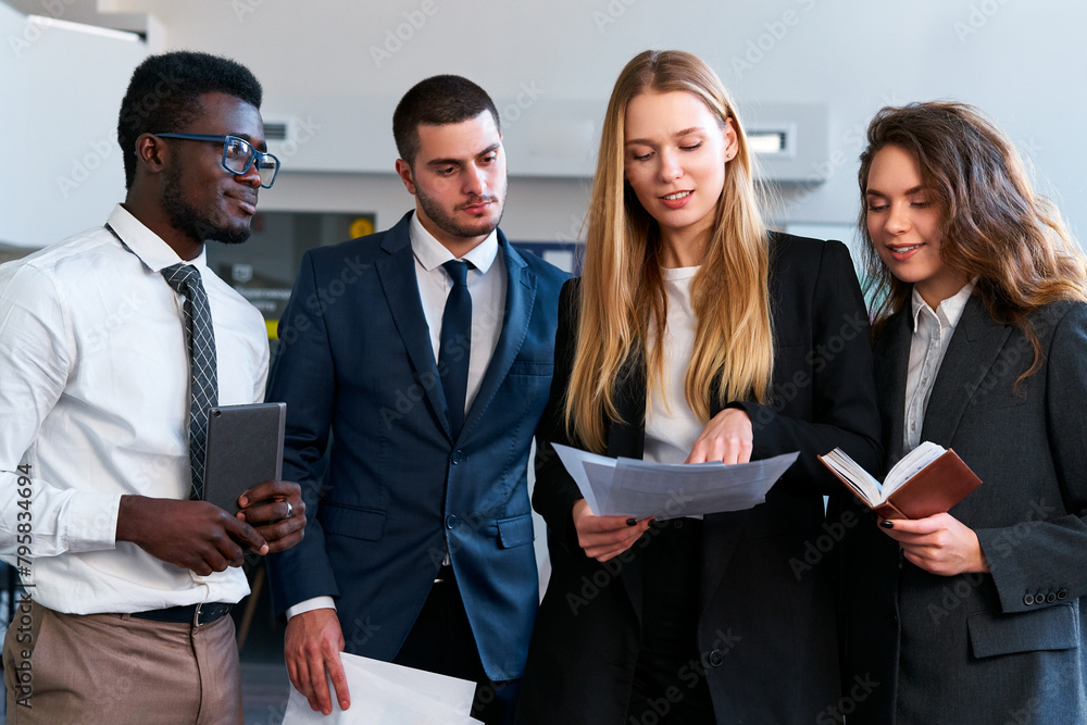 Multiethnic corporate team collaborates in office setting, reviewing ...