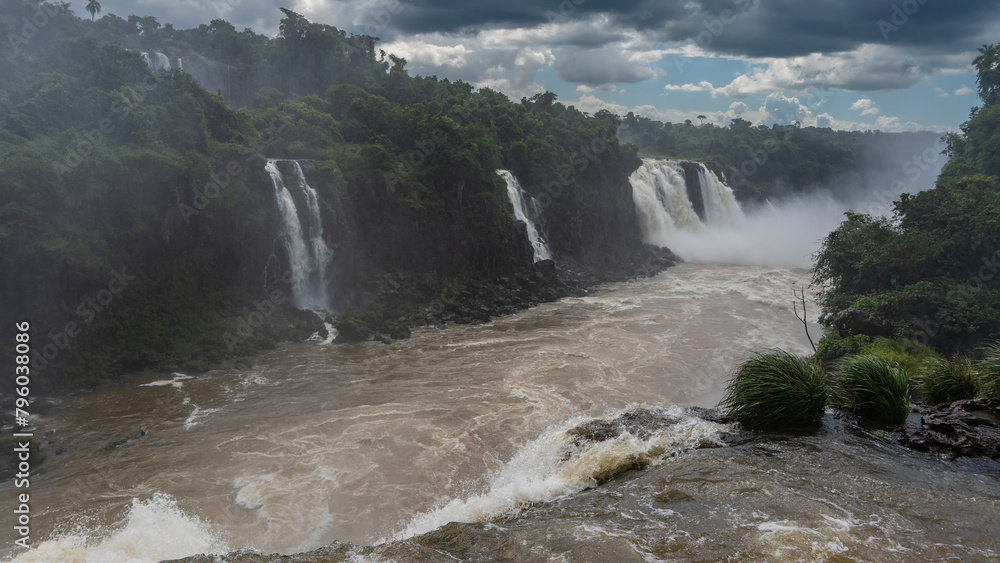A stormy river rushes through the gorge. Streams of waterfalls collapse ...