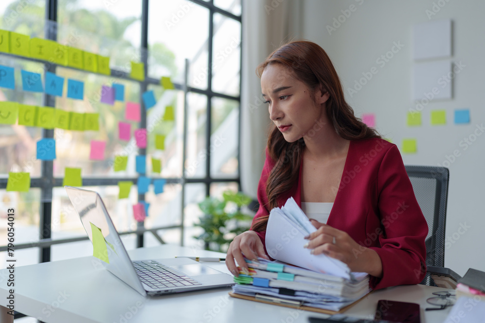 Businesswoman working in piles of paper files Data graph document to ...