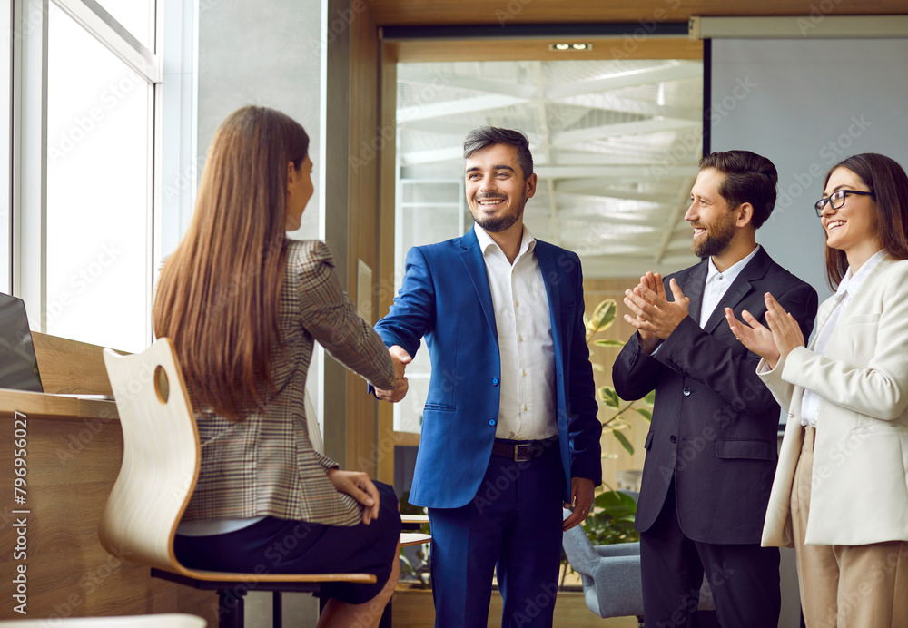 Group of young business people exchange smiles and handshakes in the ...