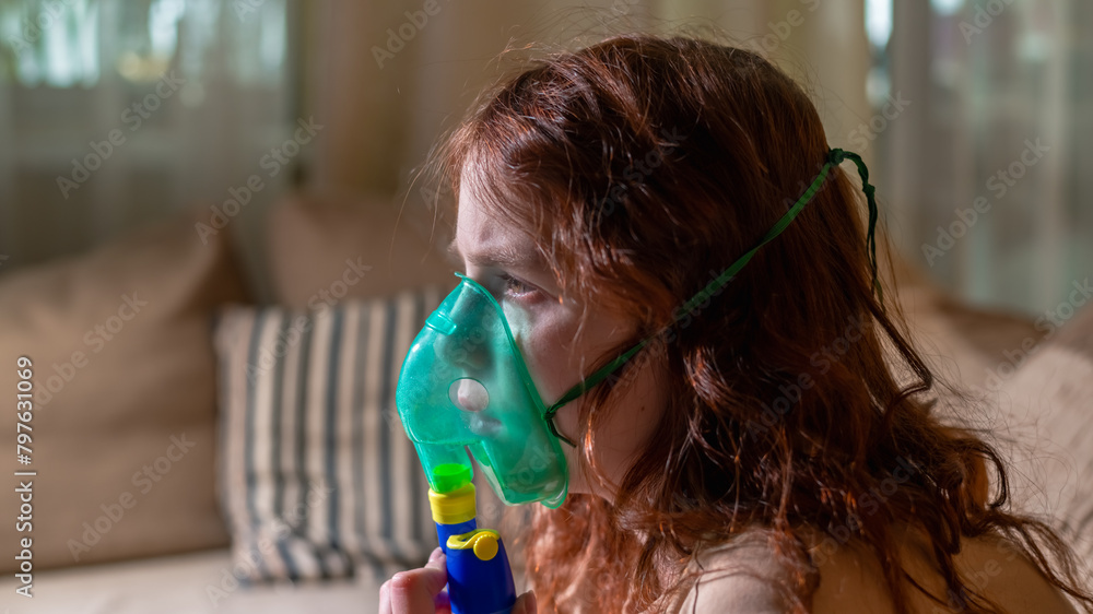 Sick girl making inhalation with nebulizer to reduce coughing, at home ...