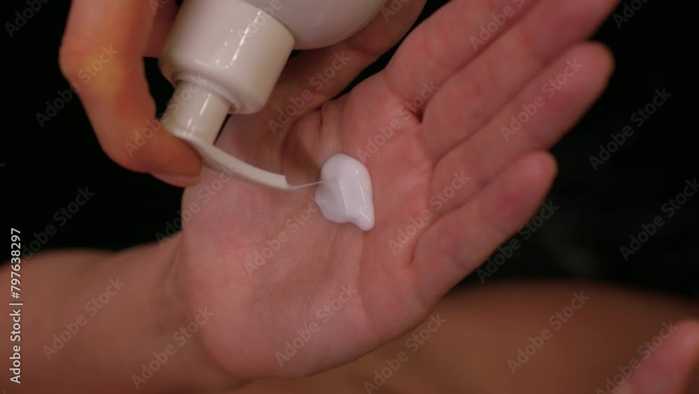 Young woman applying cream on hand against, to dry flaky skin as in the ...