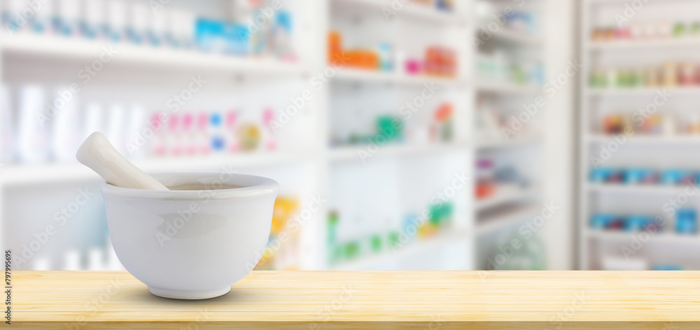 Mortar and pestle on pharmacy counter top with blur medicine shelves in ...