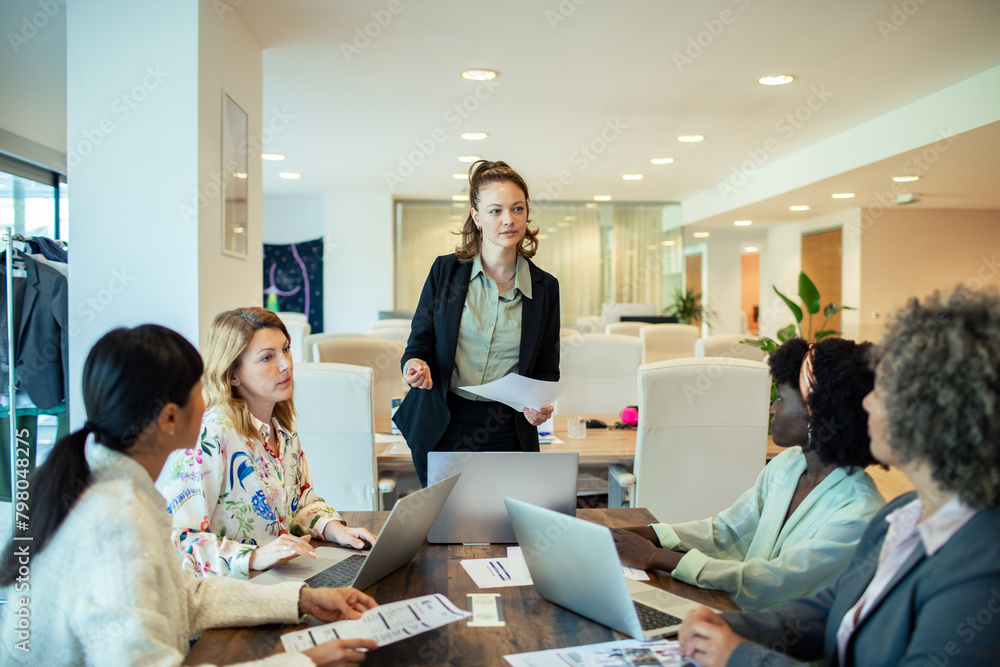 Diverse female business team working and at office desk with laptop ...