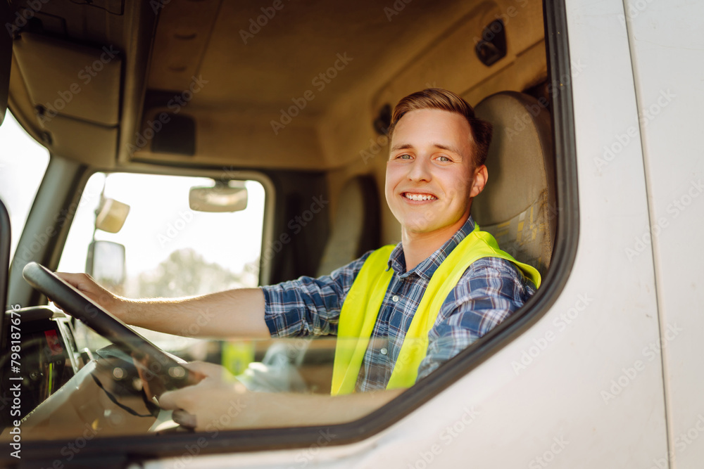 Handsome driver at the wheel of a truck at work. Driver or forwarder on ...