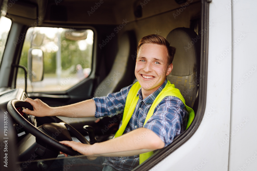 Handsome driver at the wheel of a truck at work. Driver or forwarder on ...