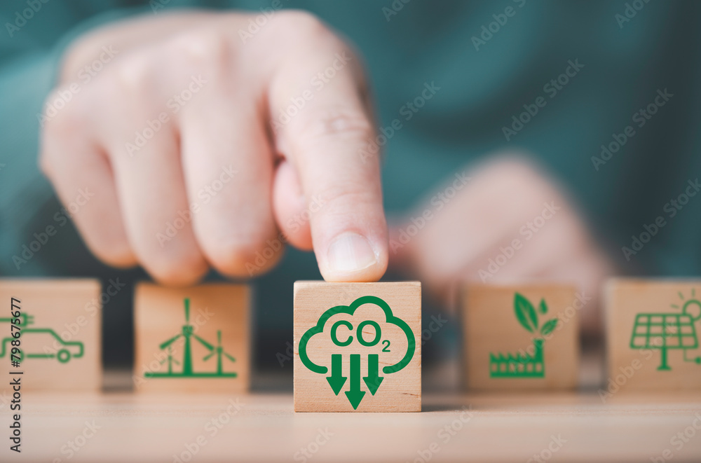 Hand pushing CO2 reducing icon in front of environment icon for decrease CO2 , carbon footprint ...