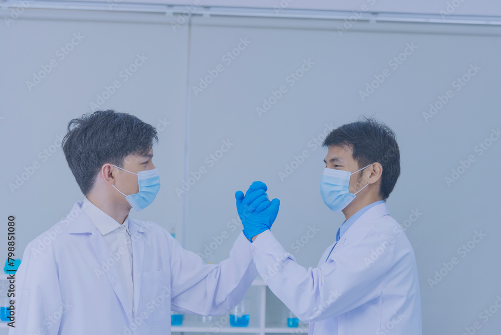 Two asian scientist men fist bump team partner shake hands together ...