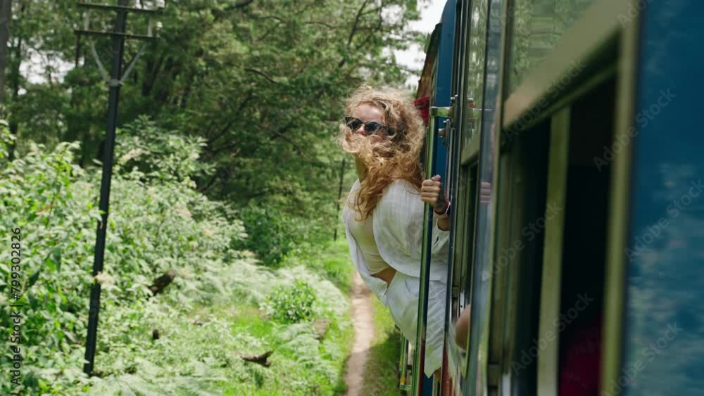 Tourist woman leans out of train, hair blowing in wind. Adventure ...