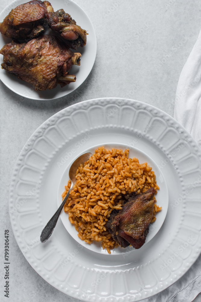 top view of Jollof rice and fried chicken on a white plate, homemade ...