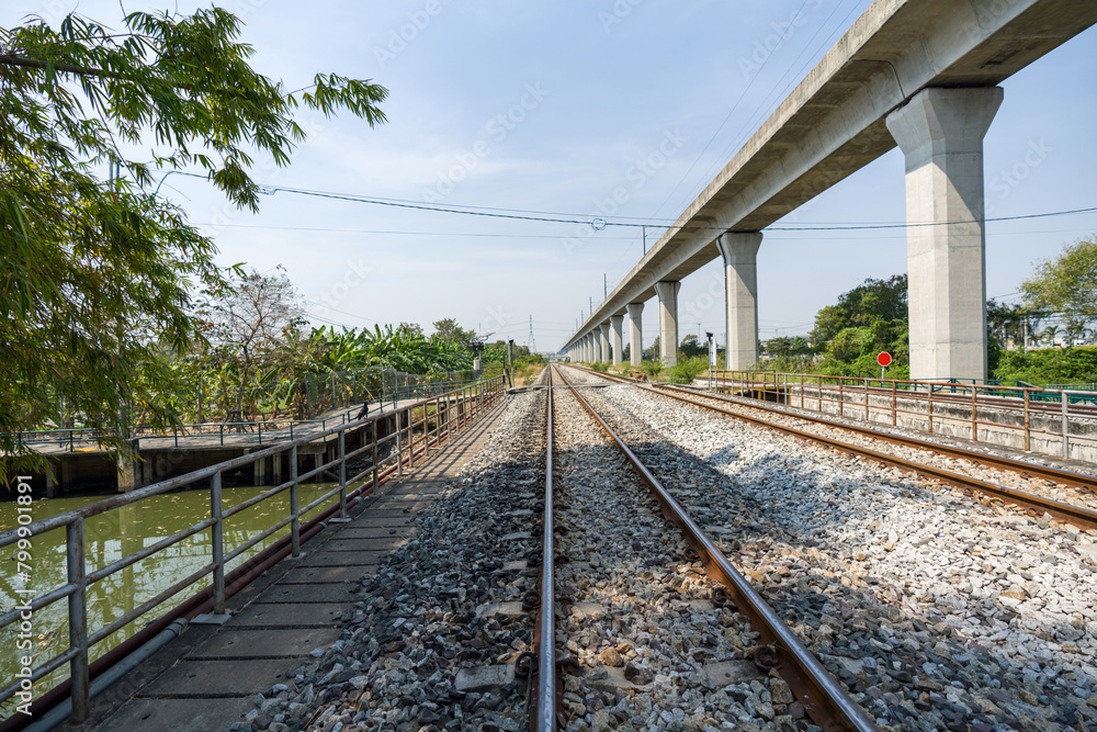 A traditional railway track lined with gravel ballast running parallel ...