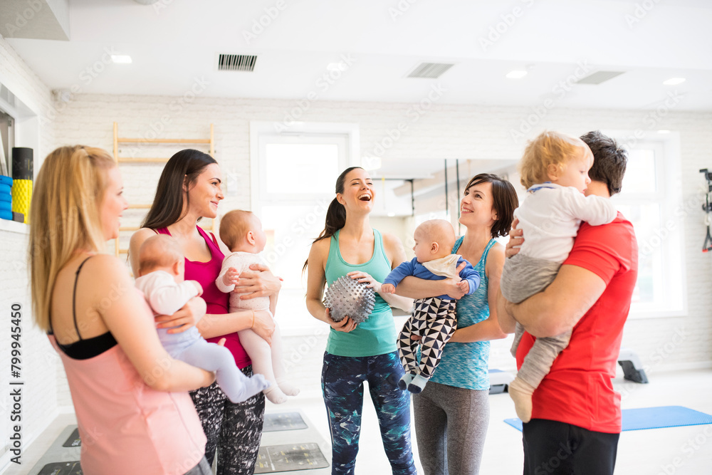 Group exercise class, mother working out with baby in gym. Moms staying ...