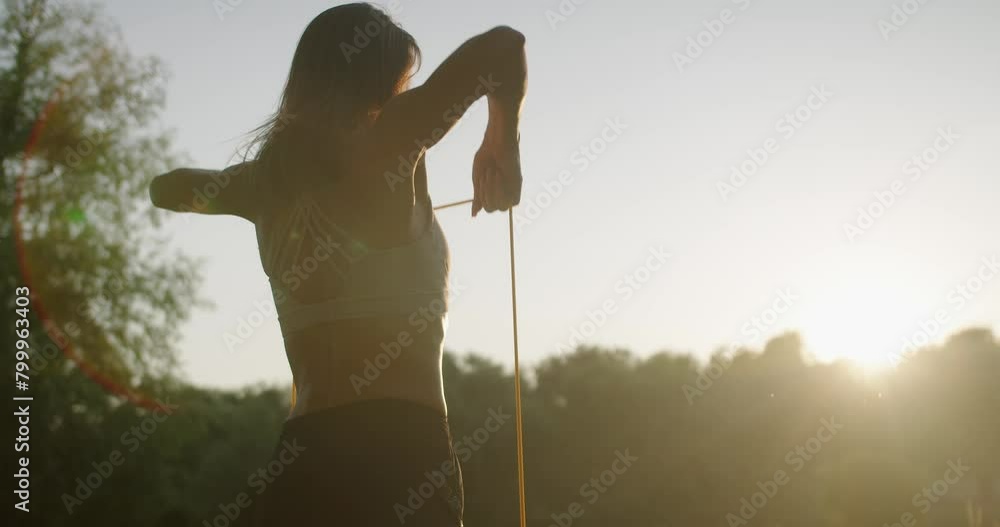 Fitness female fixing elastic band with feet and holding hands ...