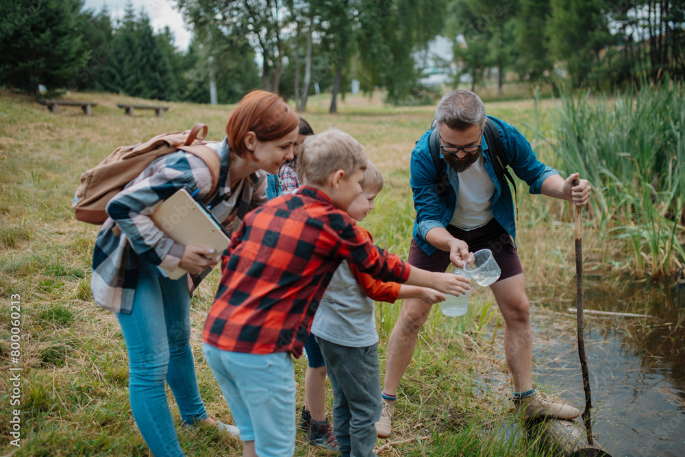 Teacher showing lake water to school children, during field teaching ...