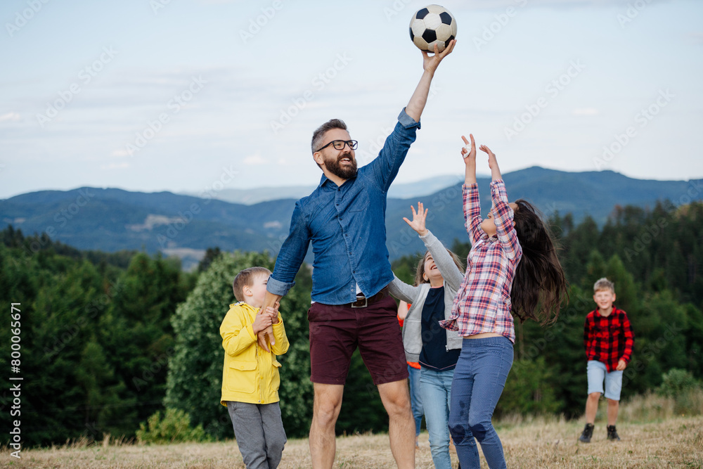 Young students playing with teacher outdoors, in nature, during field ...