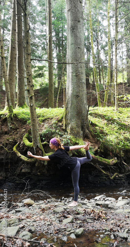 Yoga in nature. Girl in middle of forest conducts a retreat for herself ...